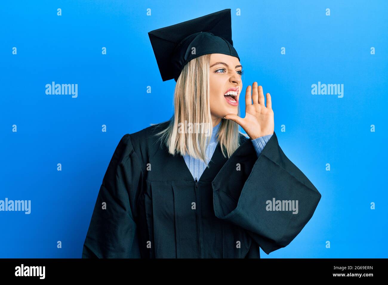 Beautiful blonde woman wearing graduation cap and ceremony robe ...