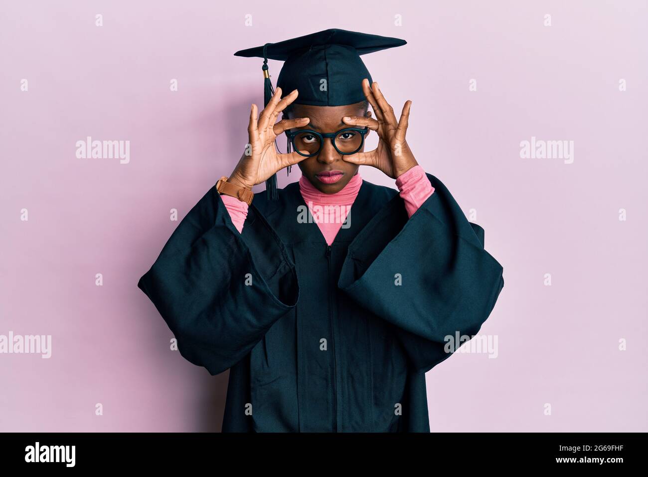 Young african american girl wearing graduation cap and ceremony robe ...