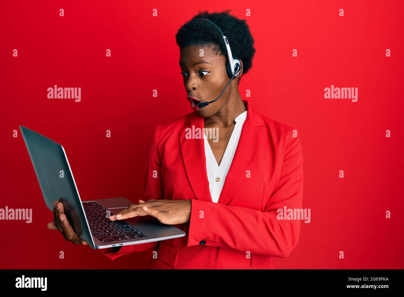 Young african american girl working at the office wearing operator ...