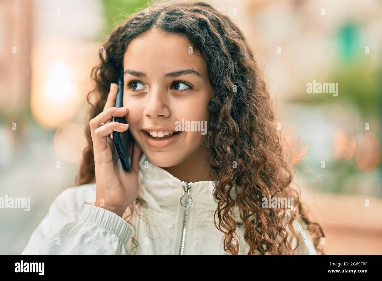 Beautiful hispanic girl smiling happy talking on the smartphone at the ...