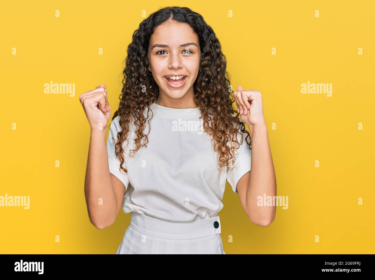 Teenager hispanic girl wearing casual white t shirt screaming proud ...