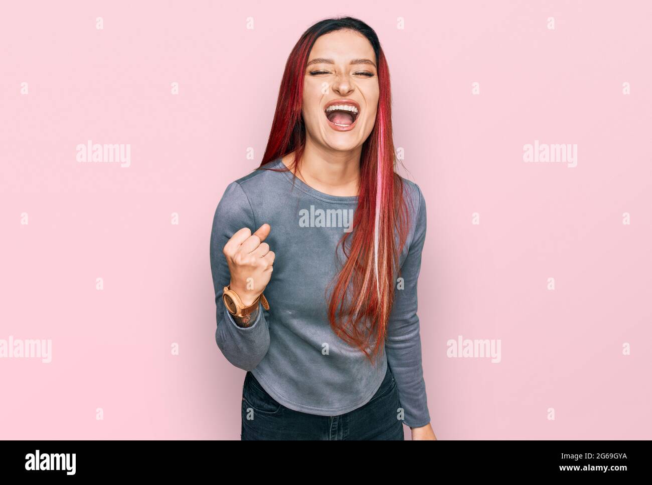 Young caucasian woman wearing casual clothes angry and mad raising fist ...