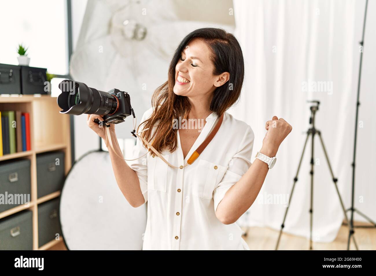 Beautiful caucasian woman working as photographer at photography studio ...