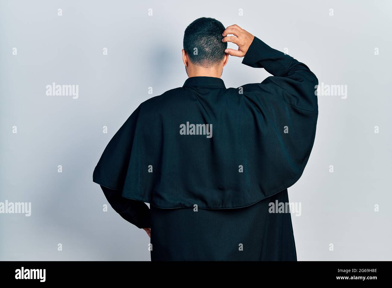 Handsome hispanic man with beard wearing catholic priest robe backwards ...