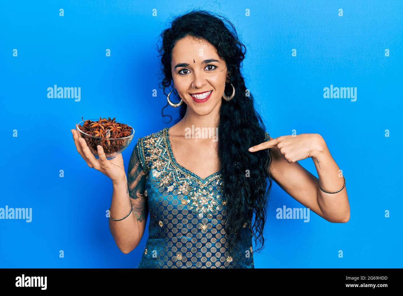 Young woman wearing bindi and traditional kurta dress holding bowl of ...