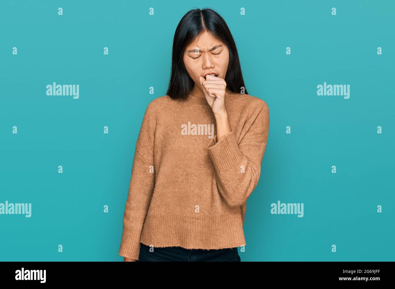 Beautiful young asian woman wearing casual winter sweater feeling ...