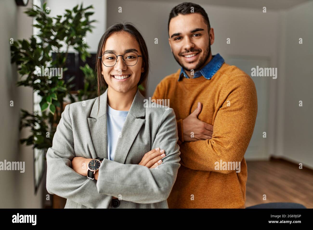 Two business workers smiling happy standing with arms crossed gesture ...