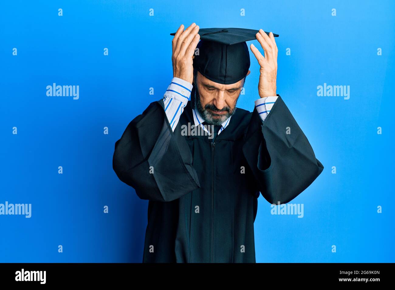 Middle age hispanic man wearing graduation cap and ceremony robe ...