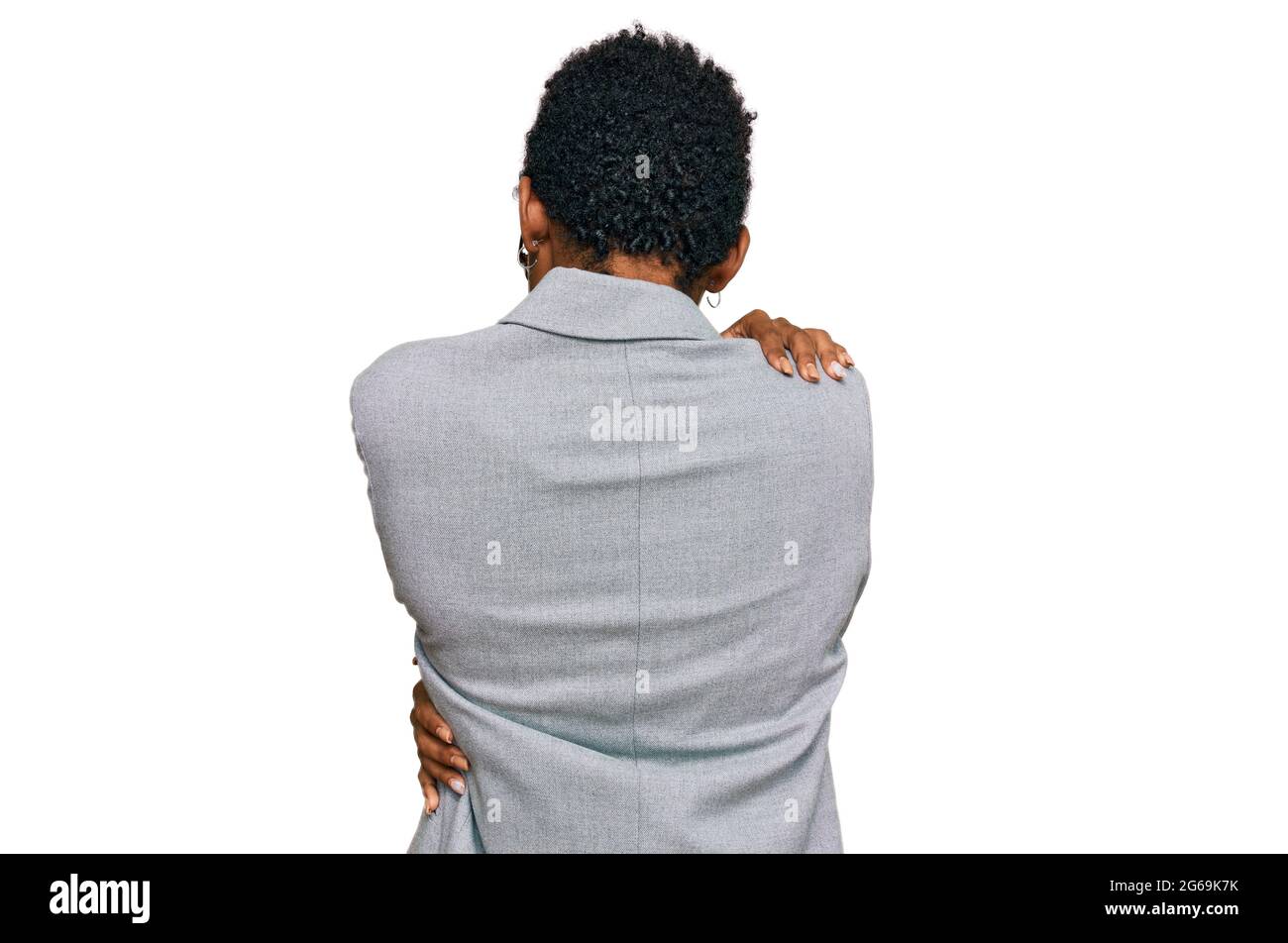 Young african american woman wearing business clothes hugging oneself ...