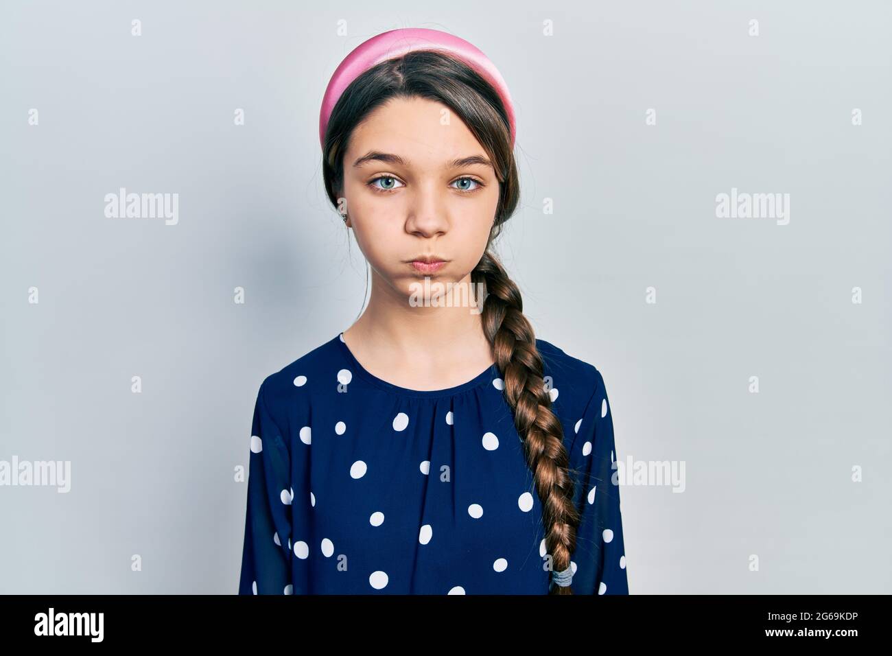 Young brunette girl wearing elegant look puffing cheeks with funny face ...