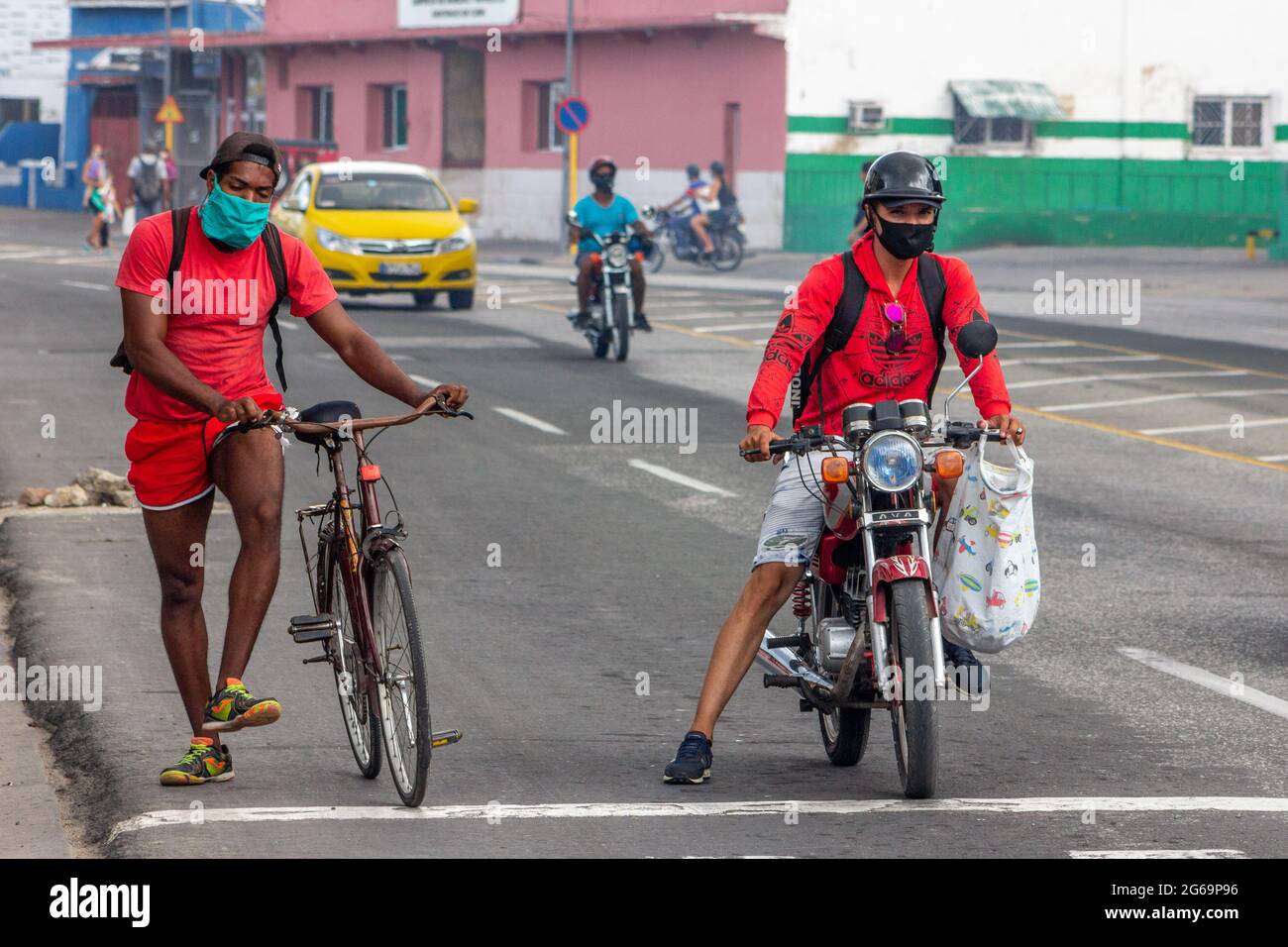 Cuban real people wearing protective face masks and driving in a city ...