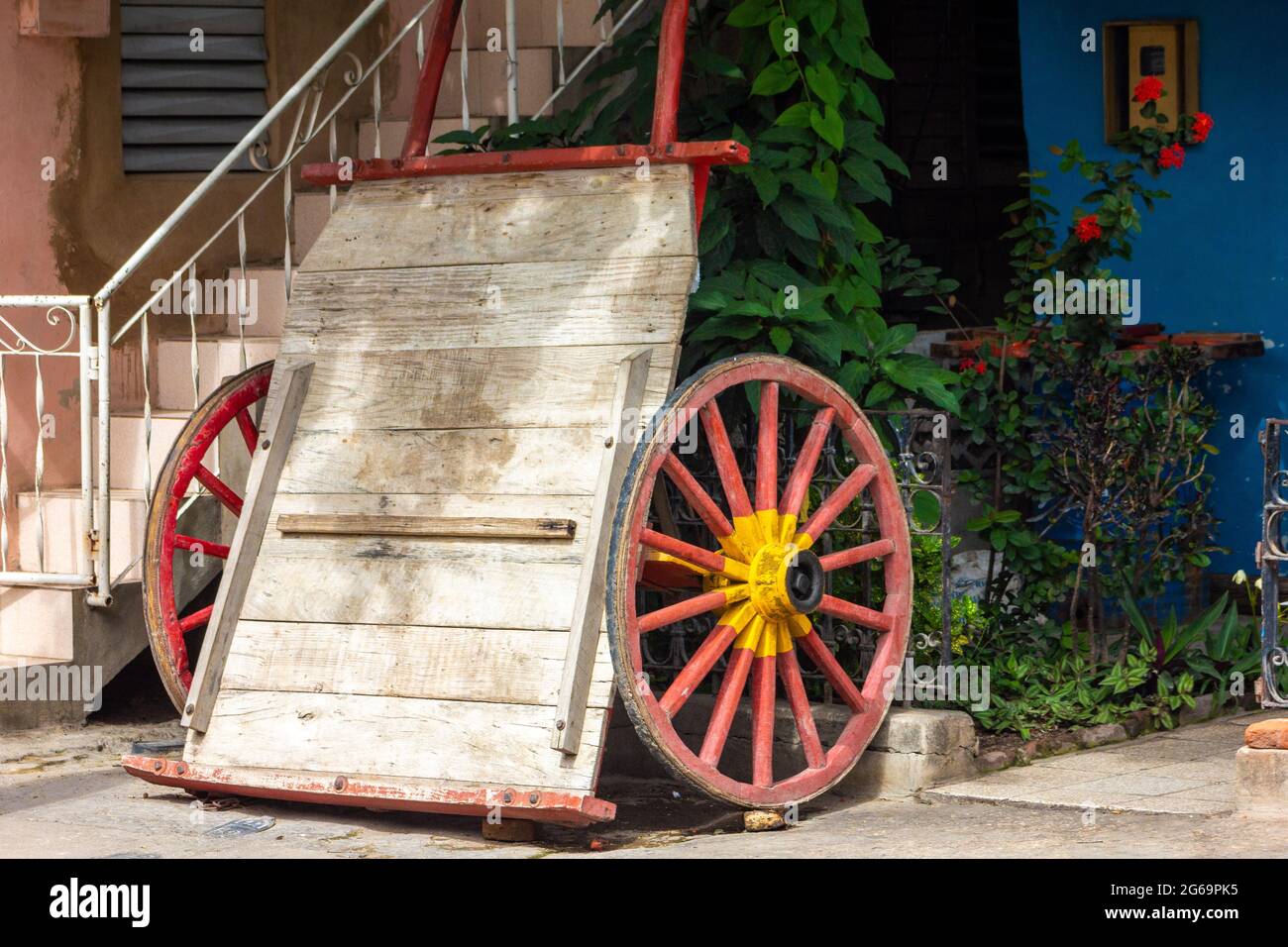 Wood colonial-style cart parked in front of a house. Rustic carts are a ...