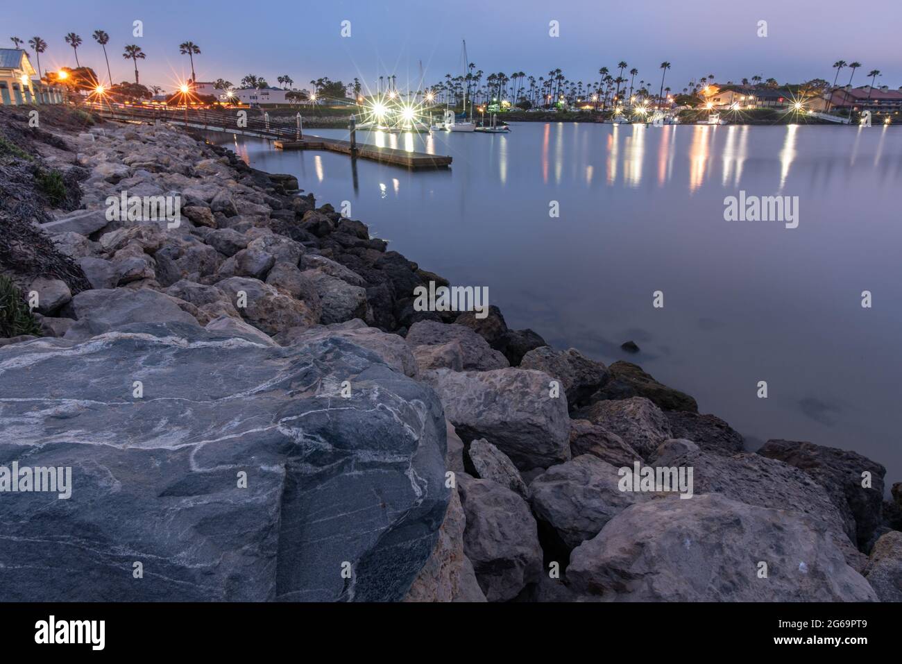 Textured rocks line the harbor cove shoreline leading up to the ...