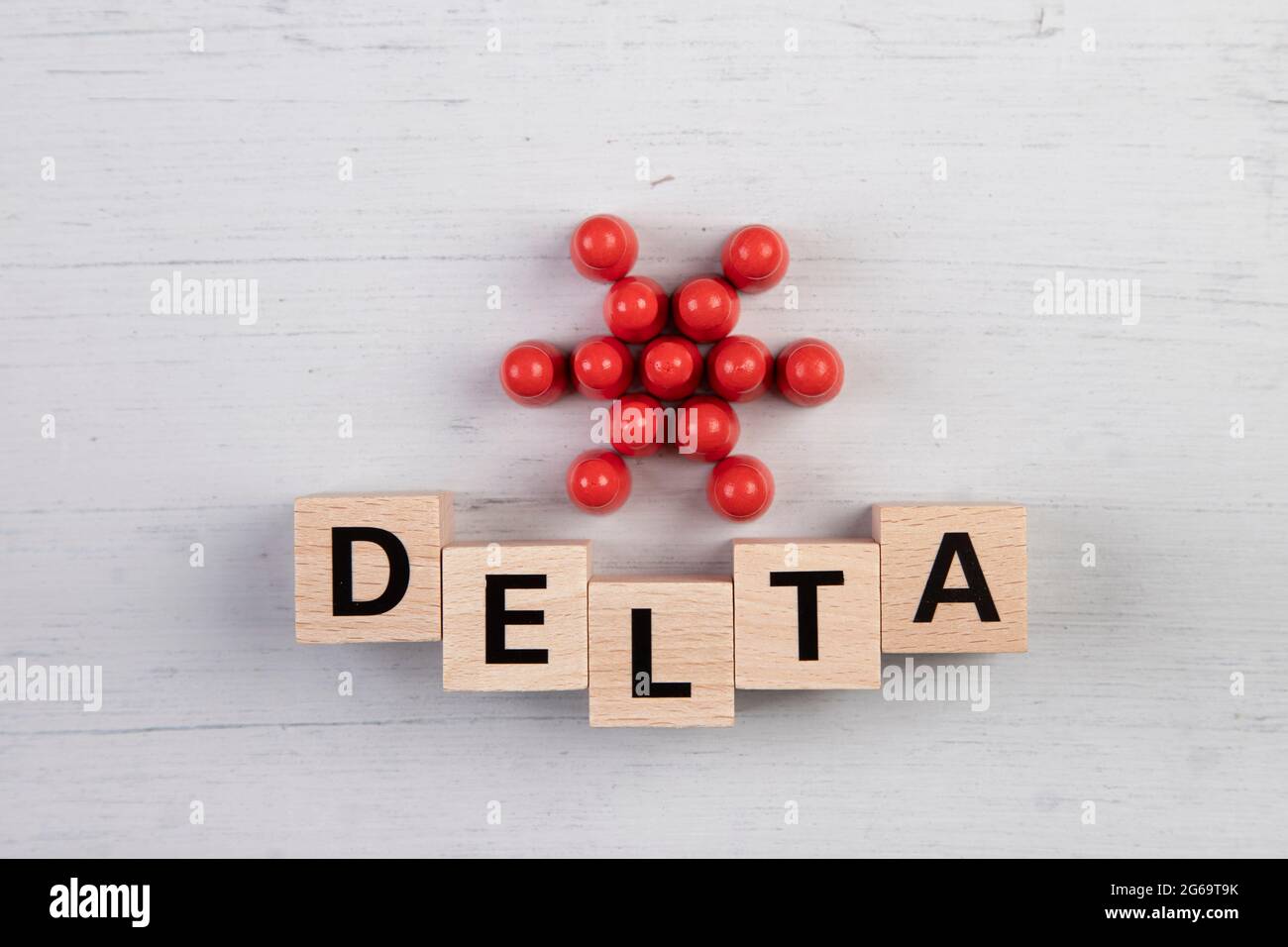 wooden blocks with the word delta and red figurines building a symbol ...