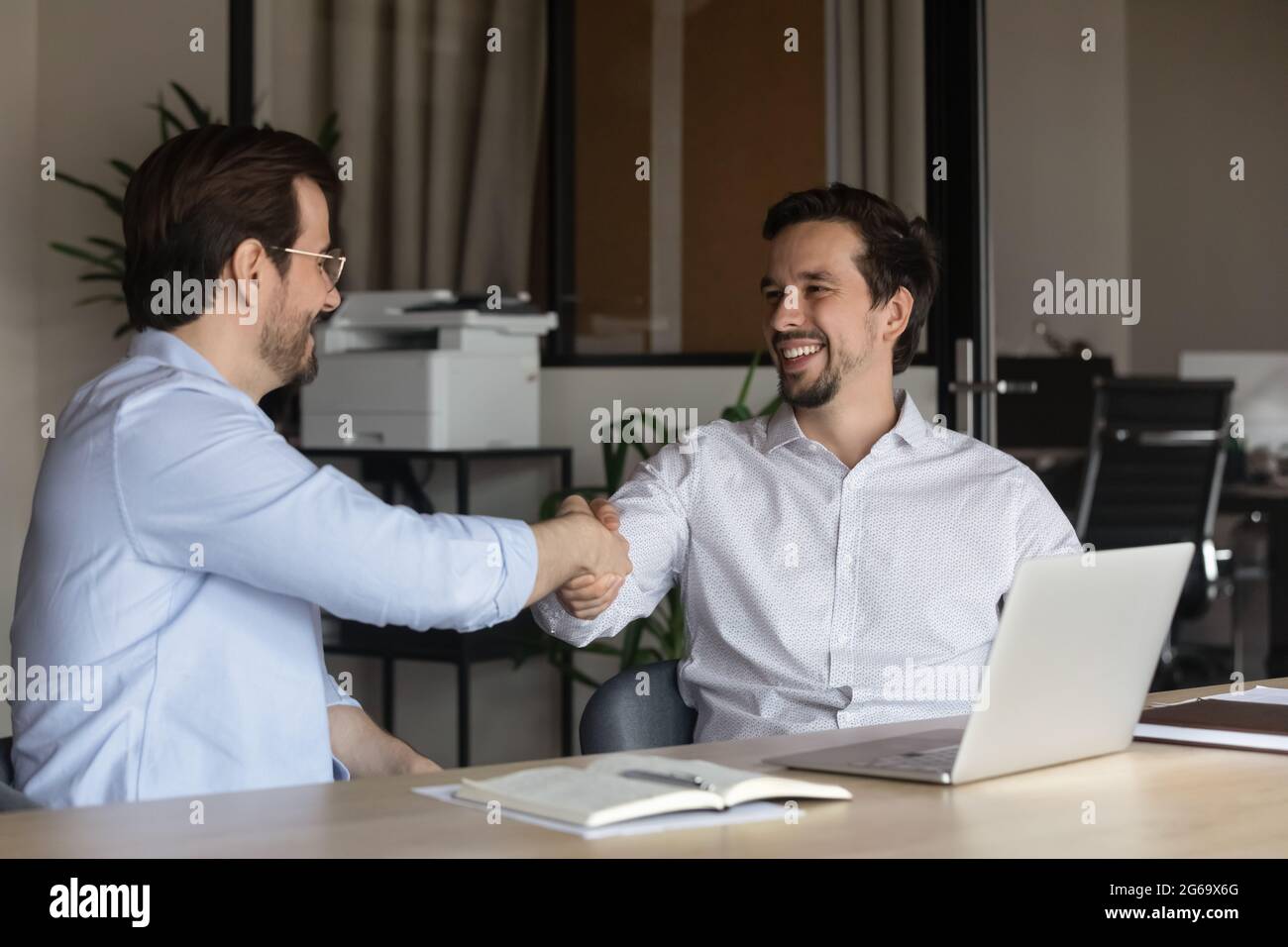Smiling hr manager shaking successful candidate hand at job interview ...