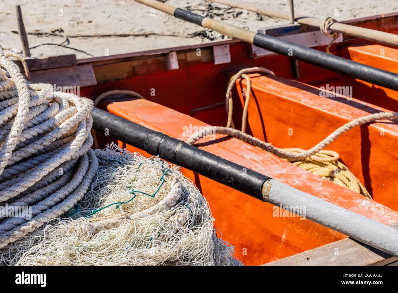 traditional fishing net and rope on small rowing boat on beach Stock ...