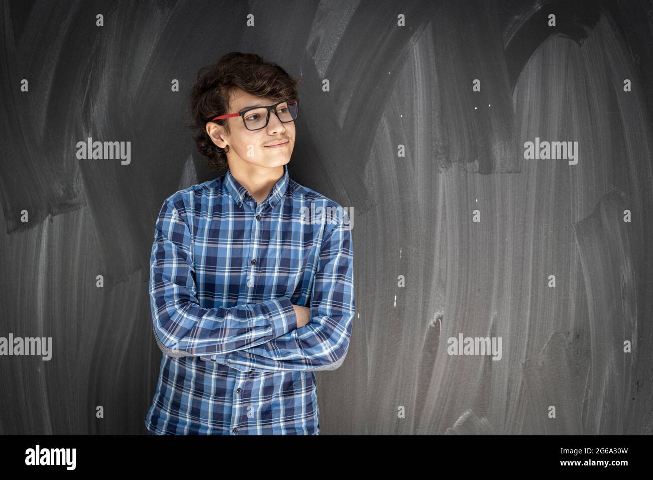 Teenage boy with glasses in front of classroom chalkboard Stock Photo ...