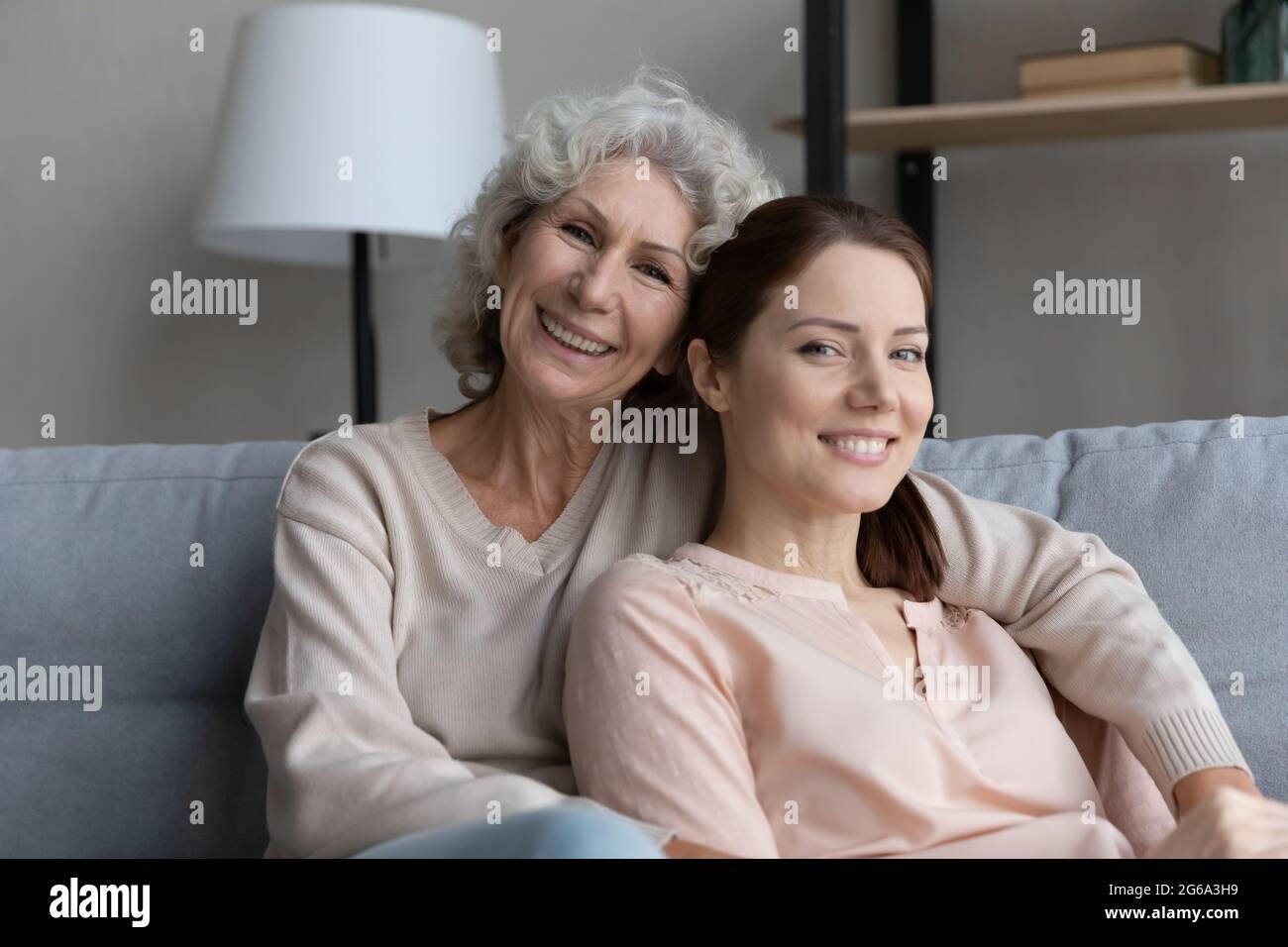 Retired woman grandma sit on sofa hug adult granddaughter Stock Photo ...
