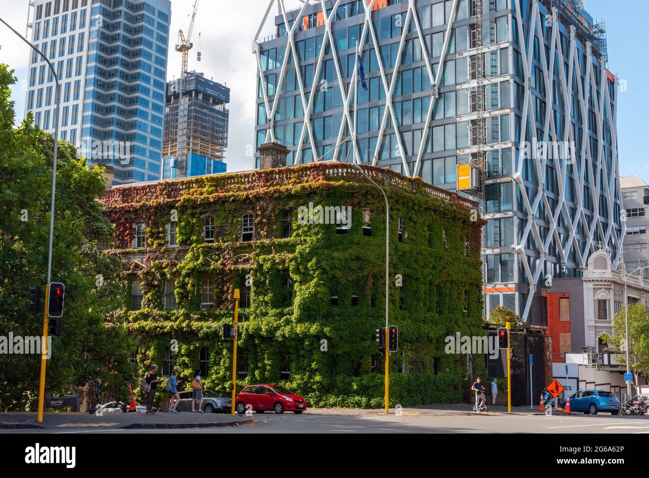 Old overgrown building between modern skyscrapers in Auckland, New ...