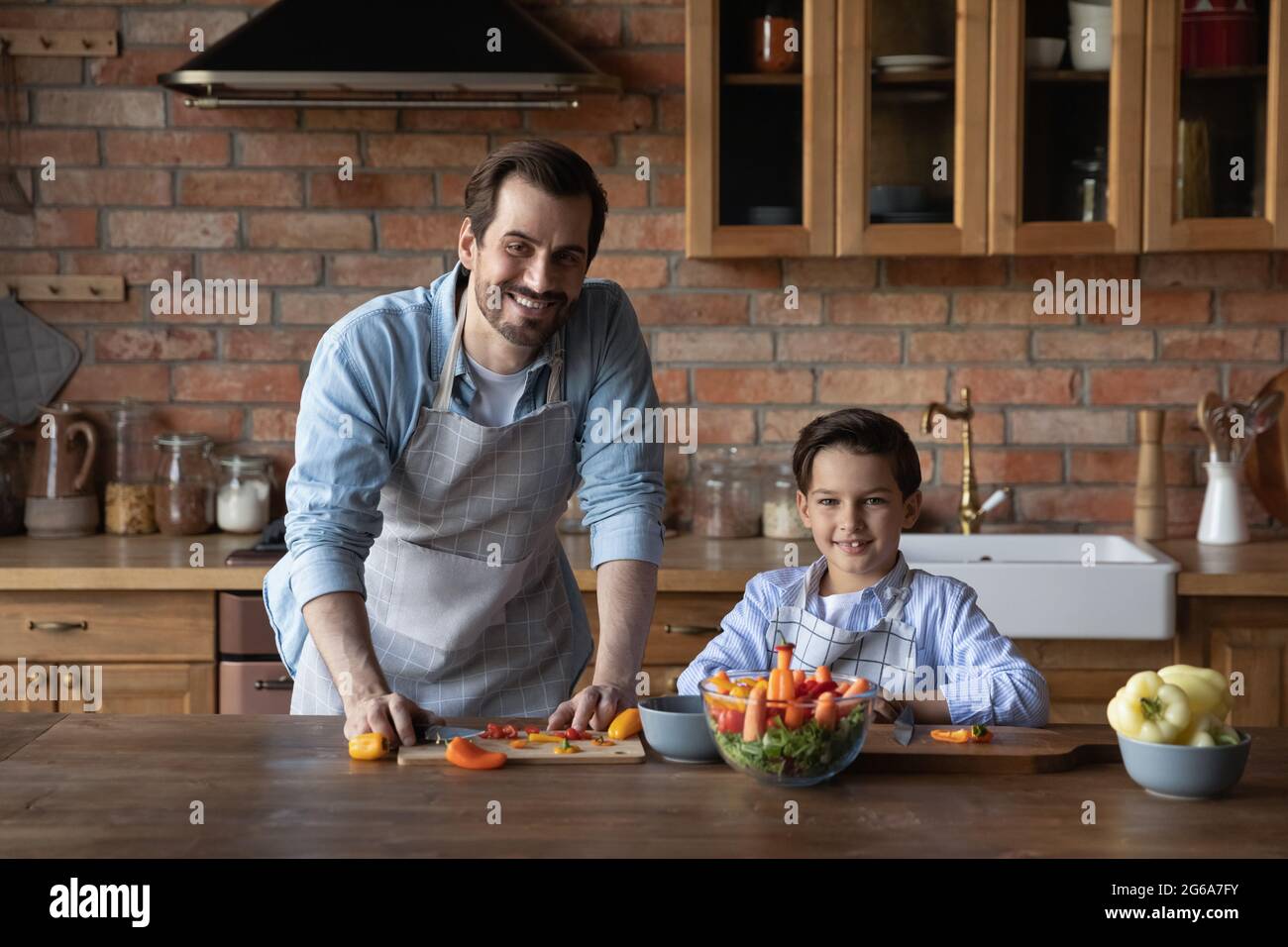 Happy cute boy in apron helping to prepare dinner Stock Photo - Alamy