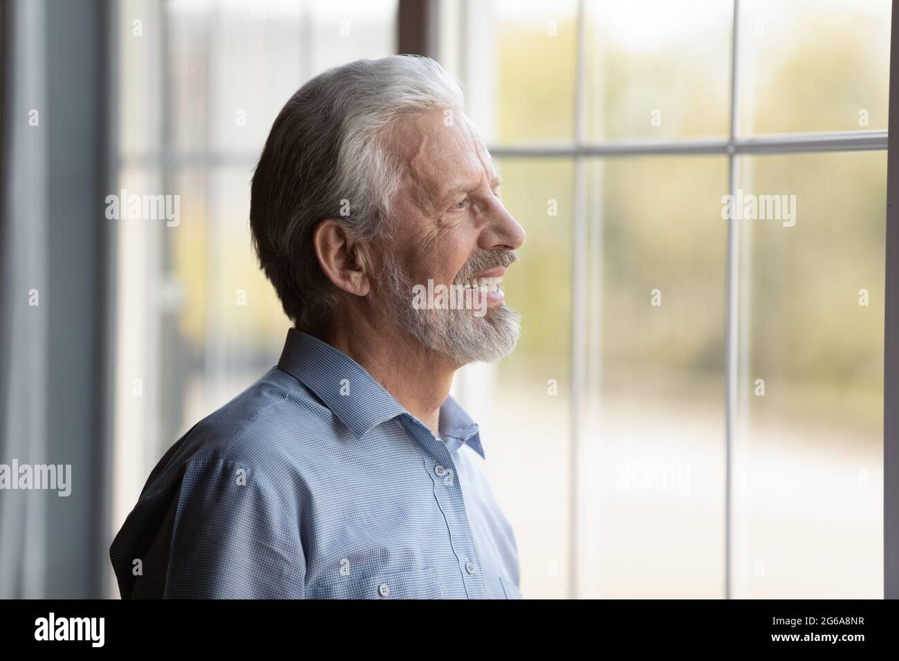 Happy thoughtful older 70s man looking out of window Stock Photo - Alamy