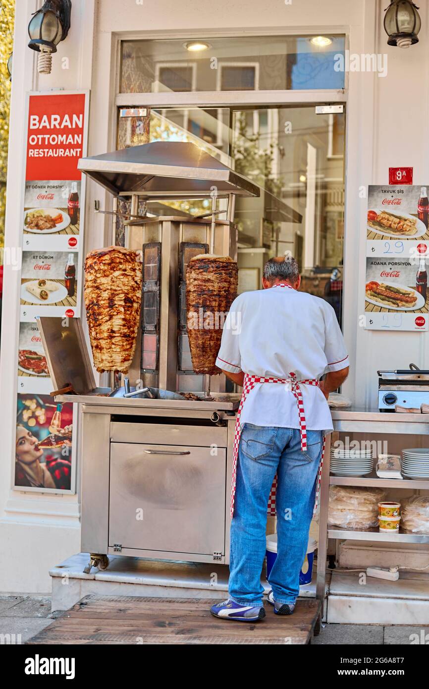 The chef prepares shawarma in a street counter in the open air. Turkish ...