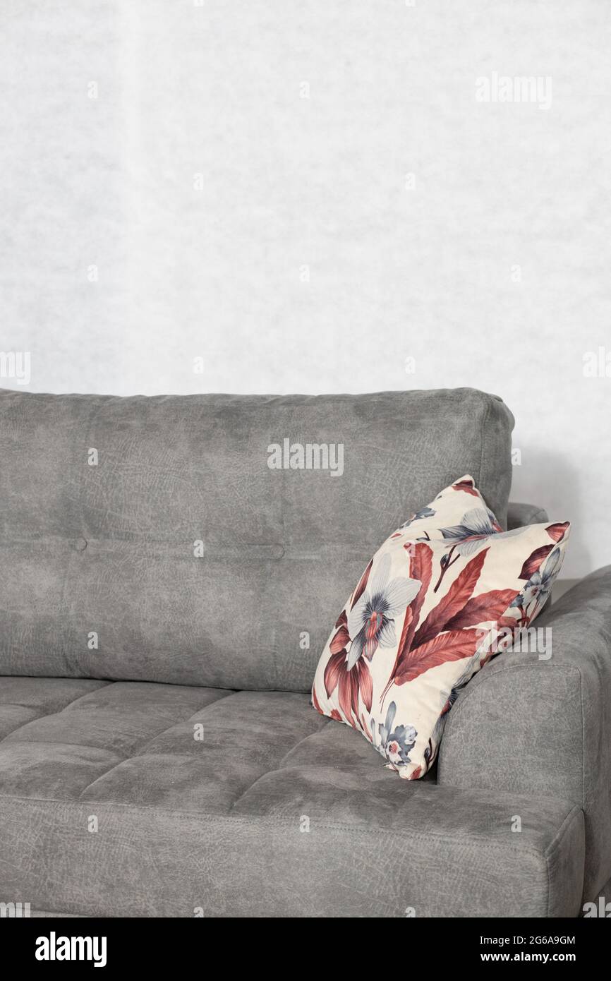 A vertical shot of a grey, modern couch with a pillow in a room Stock ...