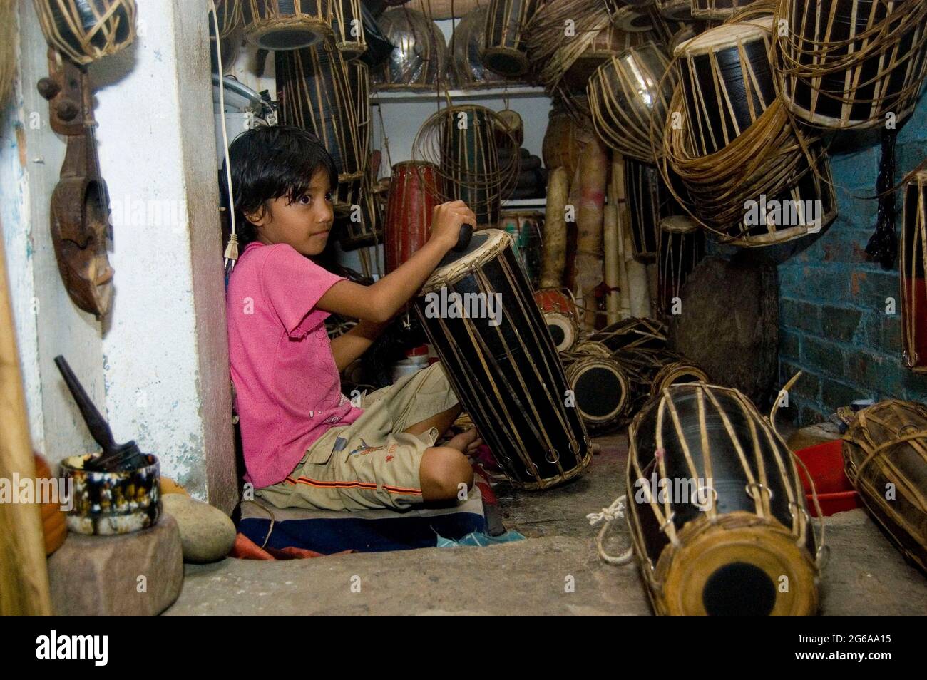A young girl making a madal, a traditional nepali musical intrument ...