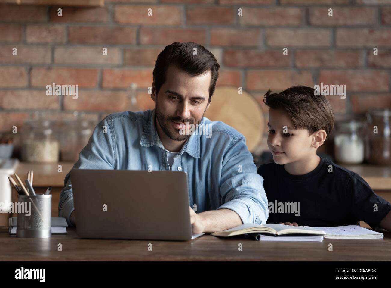 Best dad helping schoolboy son, explaining school homework to child ...