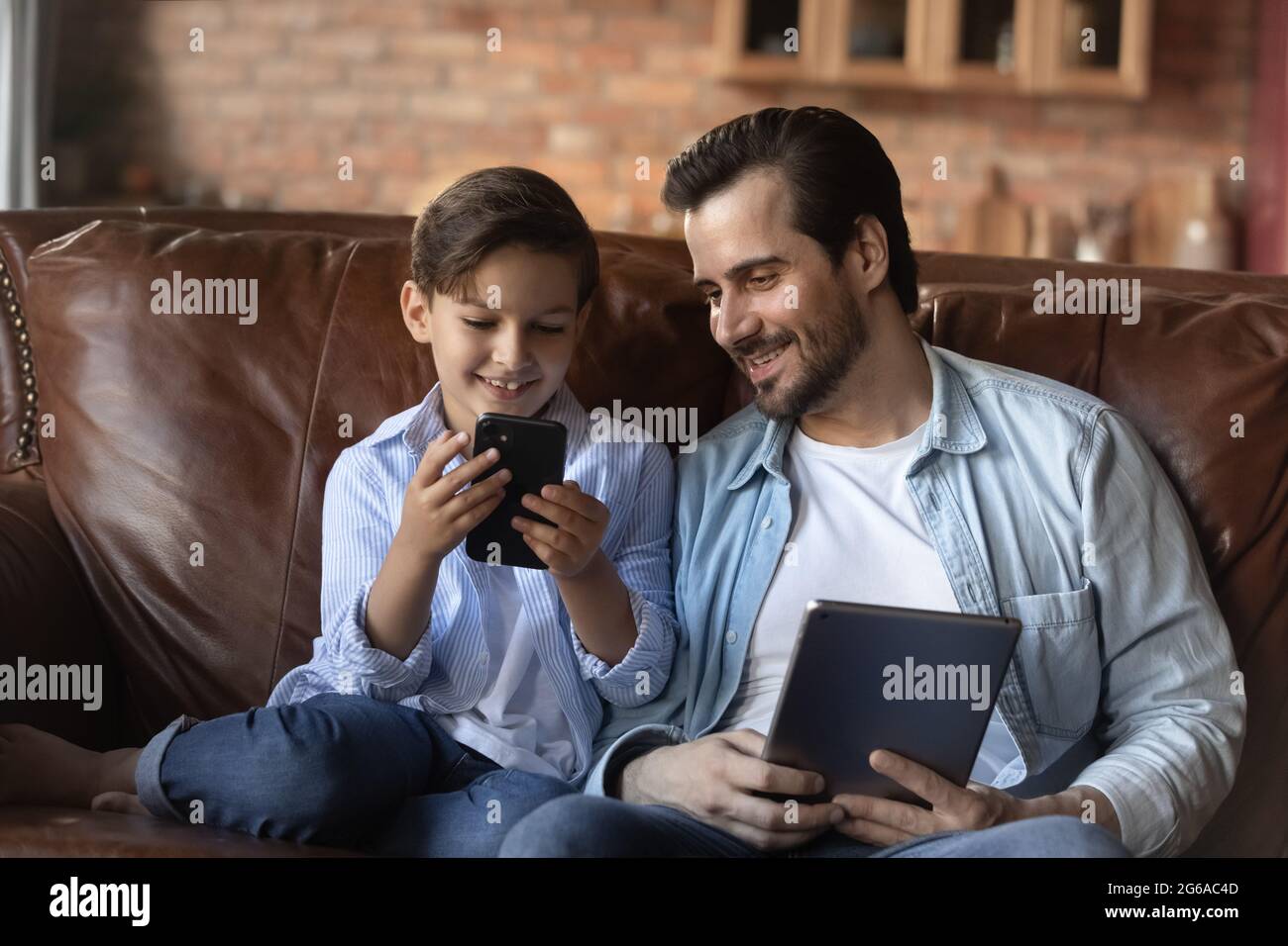 Happy gen Z boy and daddy using gadgets at home Stock Photo - Alamy