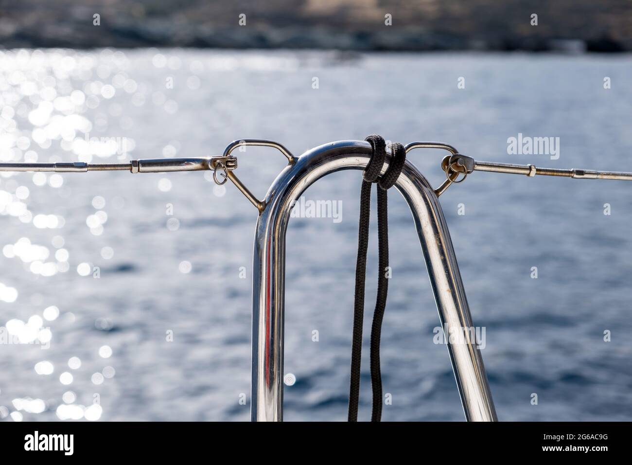 Boat railing detail. Black rope tied on stainless steel guard rail ...