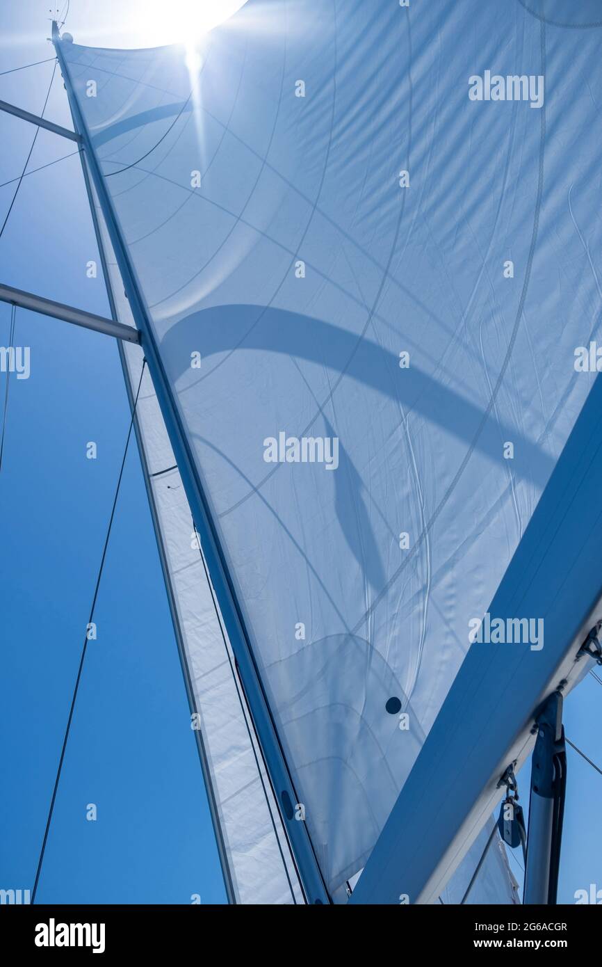 Yacht wind filled sails on clear blue sky background. Sailing with the ...