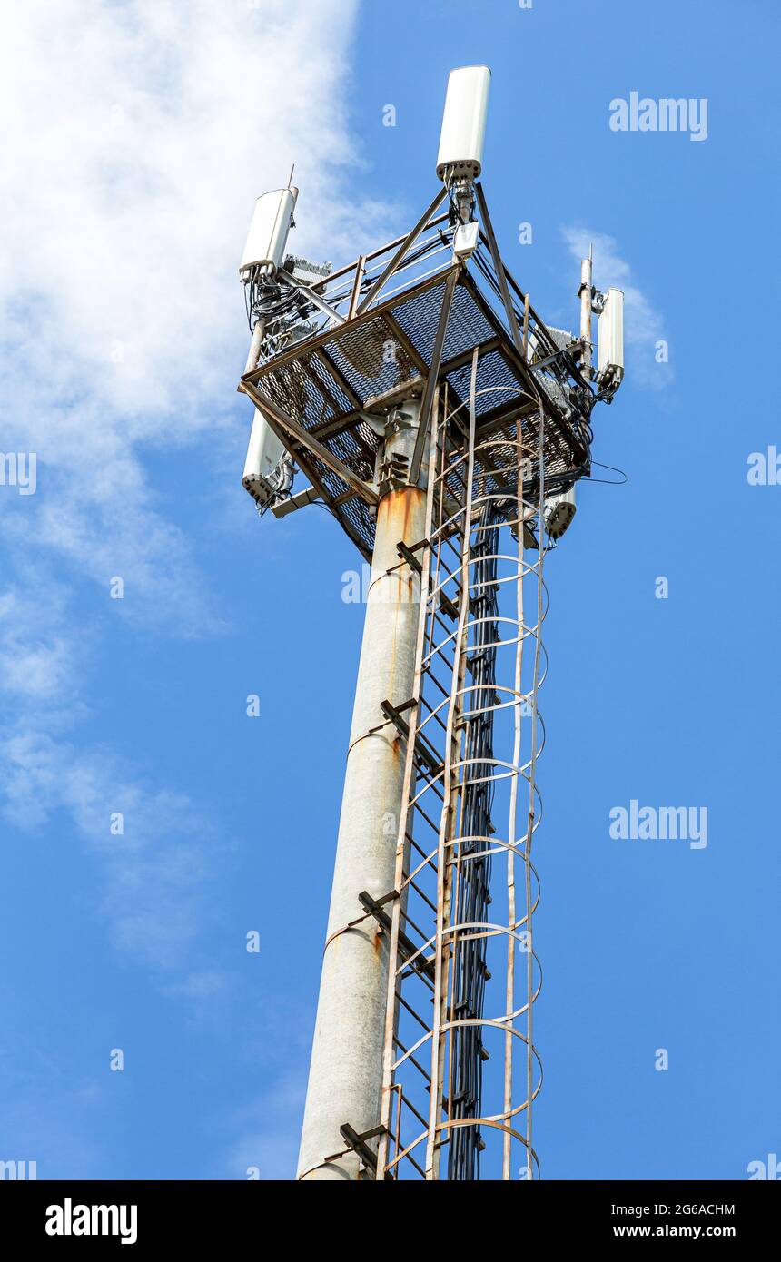 Telecommunication tower for mobile phone with antennas over a blue sky. Distribution function of ...