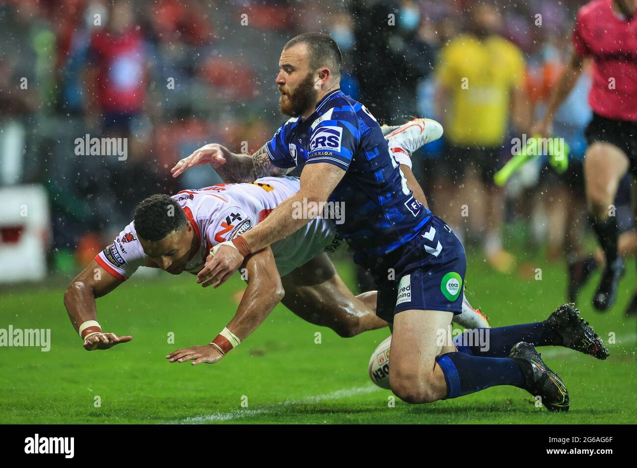Jake Bibby (22) of Wigan Warriors tackles Regan Grace (5) of St Helens ...
