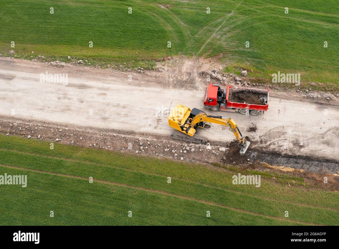 Excavator digging ground near the field and loading to the truck Stock ...