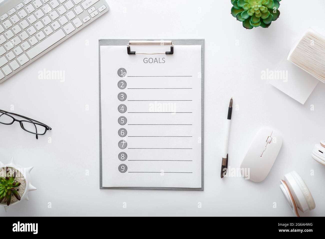 Goals list on workspace on white background. Flat lay, top view office ...