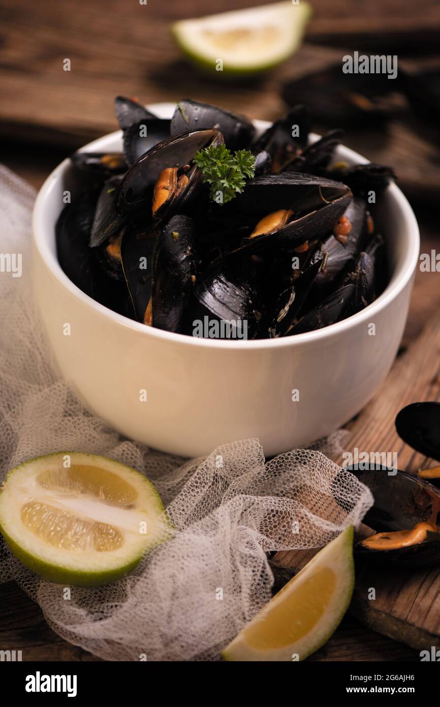 Cooked mussels in a withe bowl close up Stock Photo - Alamy