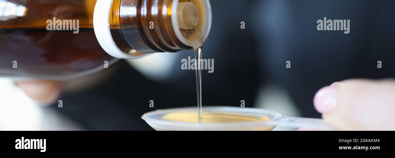 Woman pouring medicinal syrup into measuring spoon closeup Stock Photo ...