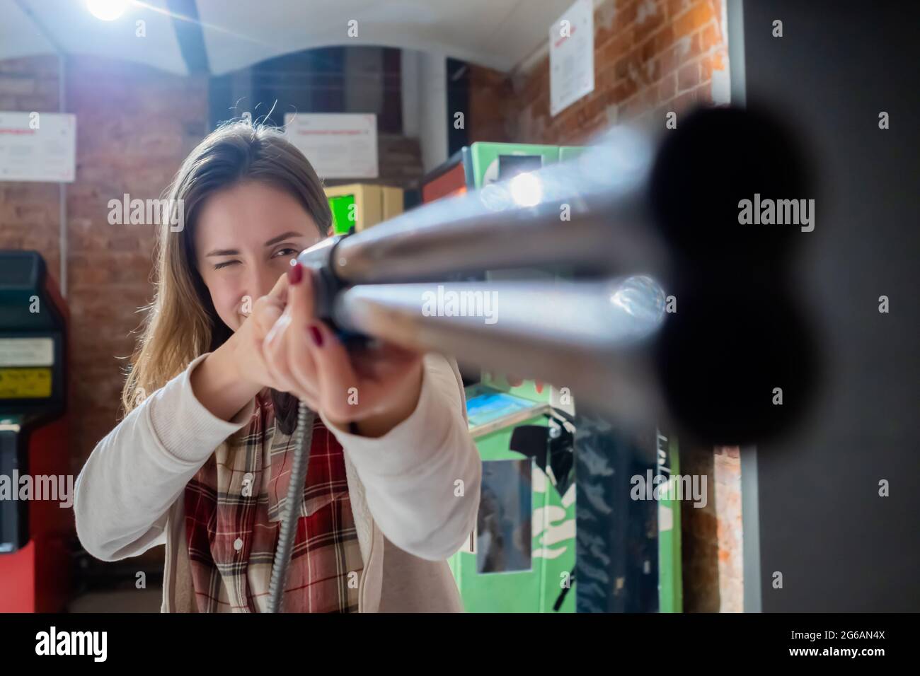 Woman gamer playing vintage shooting arcade game Stock Photo - Alamy