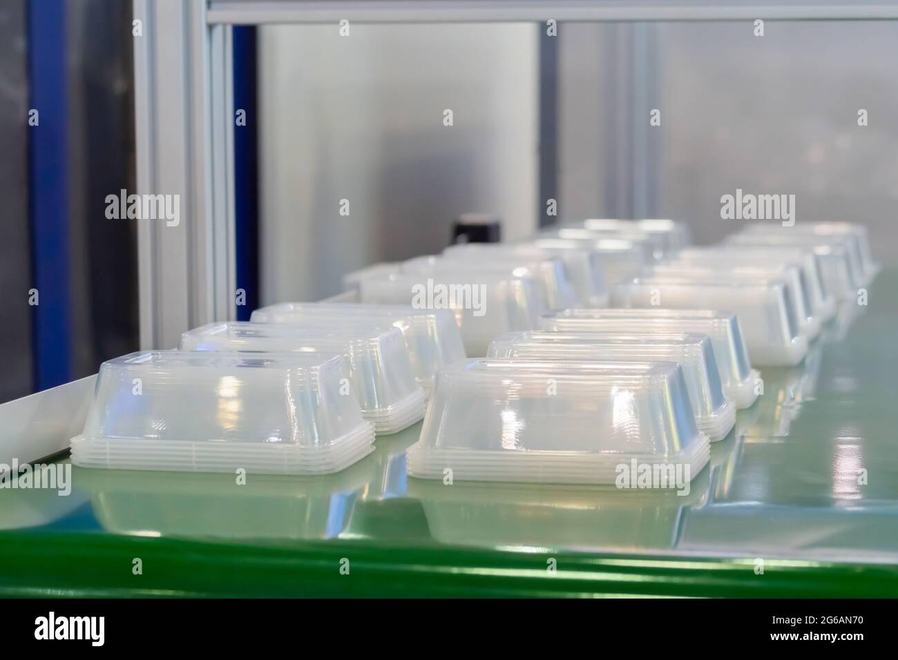Empty food containers on conveyor belt of plastic injection molding ...