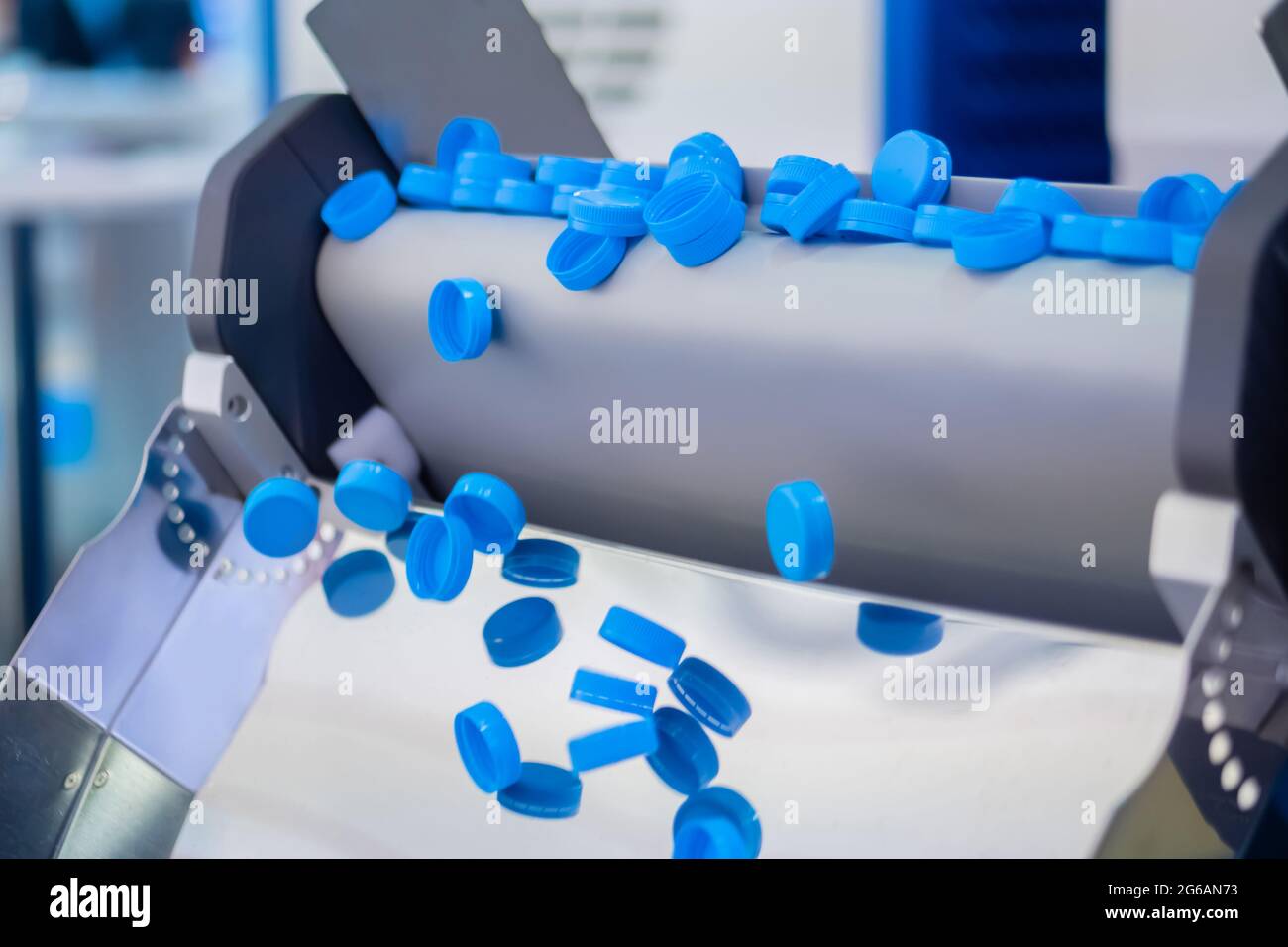 Production line - many blue plastic bottle caps falling from conveyor ...
