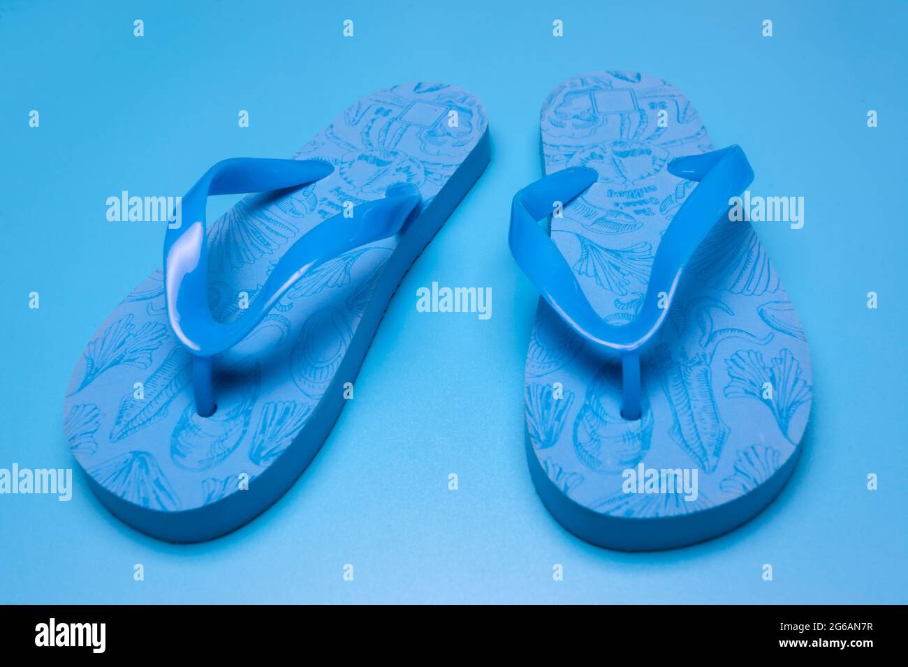 Blue flip flops on a blue background Stock Photo - Alamy