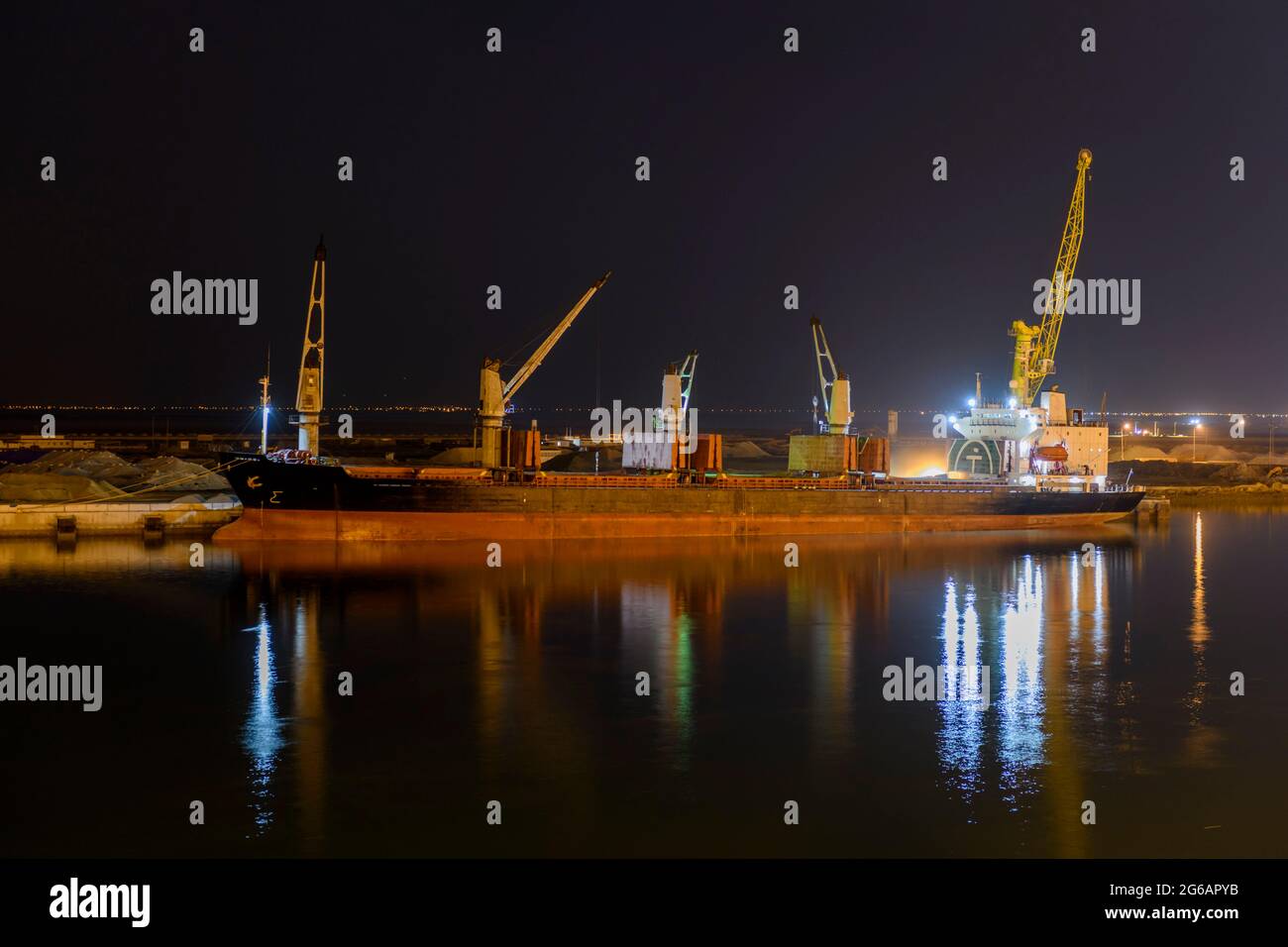 Bulk carrier vessel moored alongside berth in port. Night view. Bulker ...