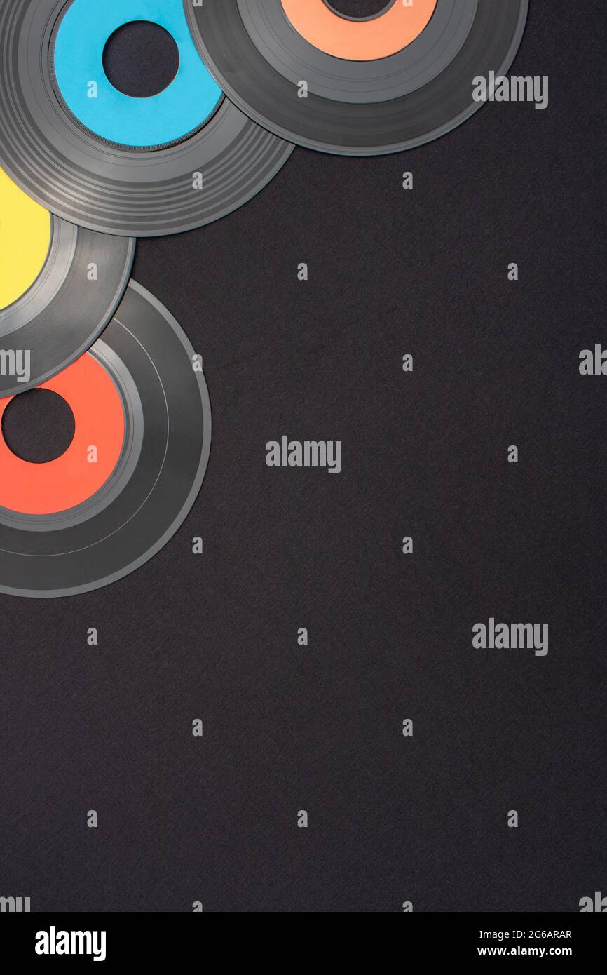 Multi colored 7 inch single vinyl records on a black background with ...