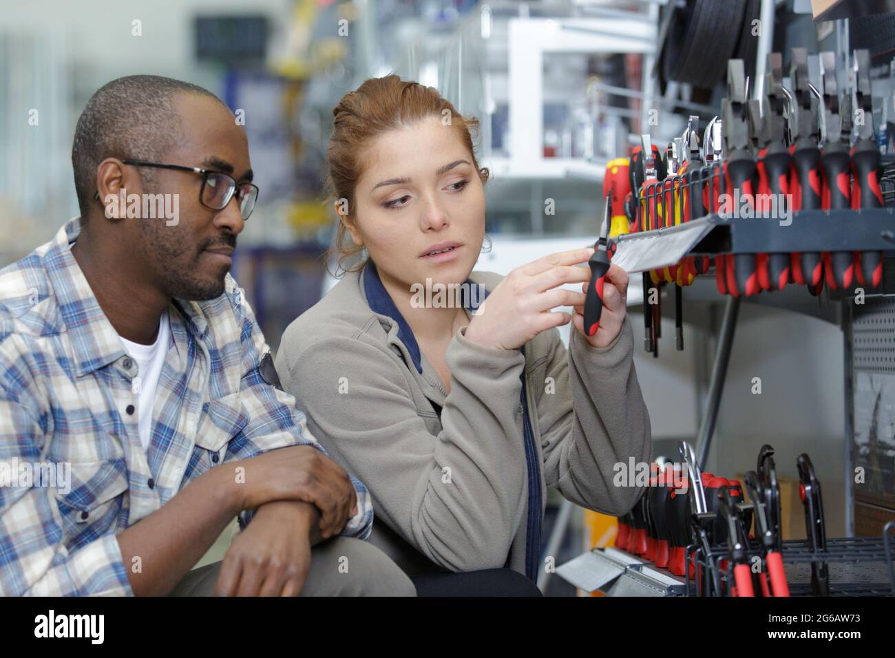 playful couple looking at tools in hardware store Stock Photo - Alamy