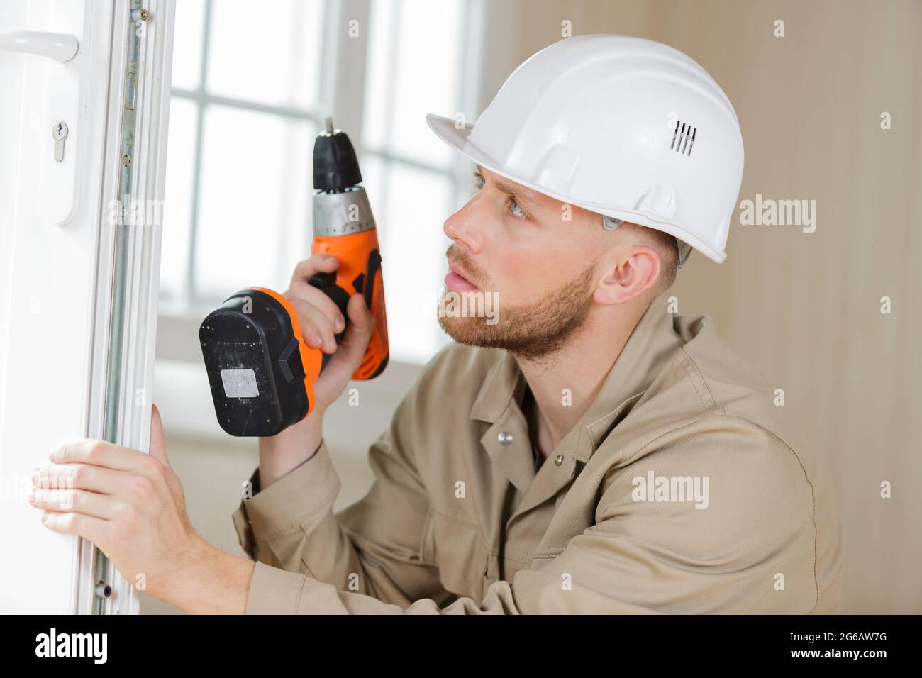 a man drilling window frame Stock Photo - Alamy