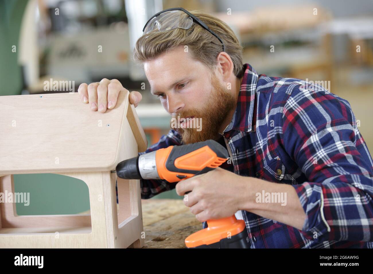 male worker assembly a small wood house Stock Photo - Alamy