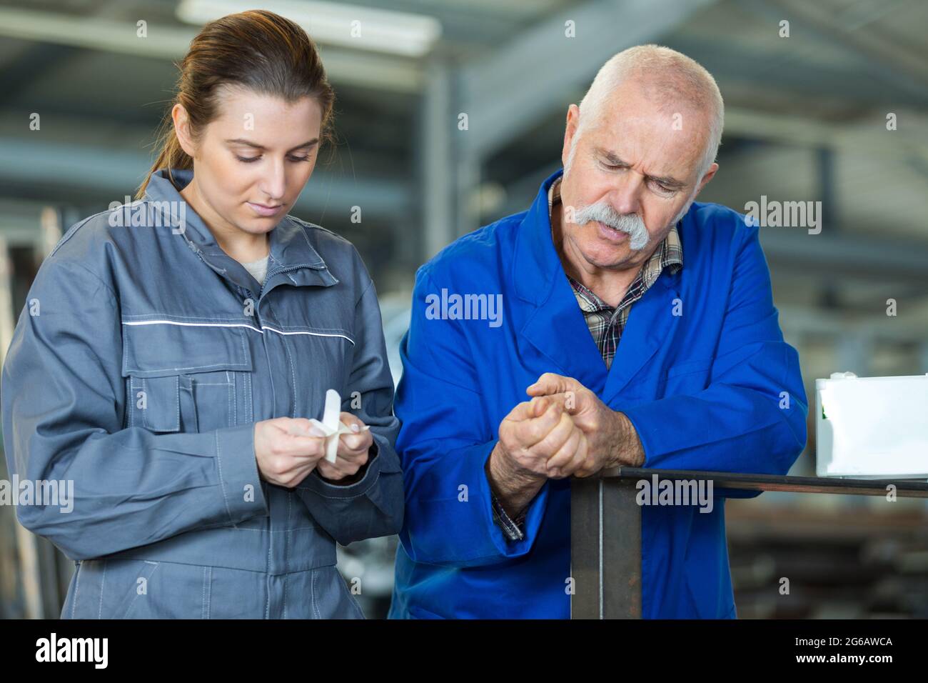 female and senior manufacturing labourers working together Stock Photo ...