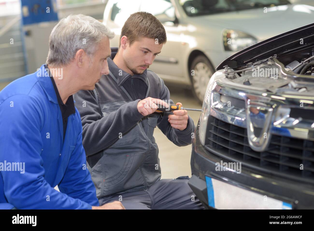 student with instructor repairing a car during apprenticeship Stock ...