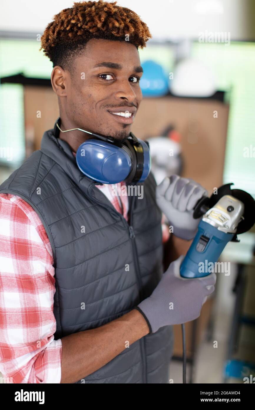 a builder with an angle grinder Stock Photo - Alamy